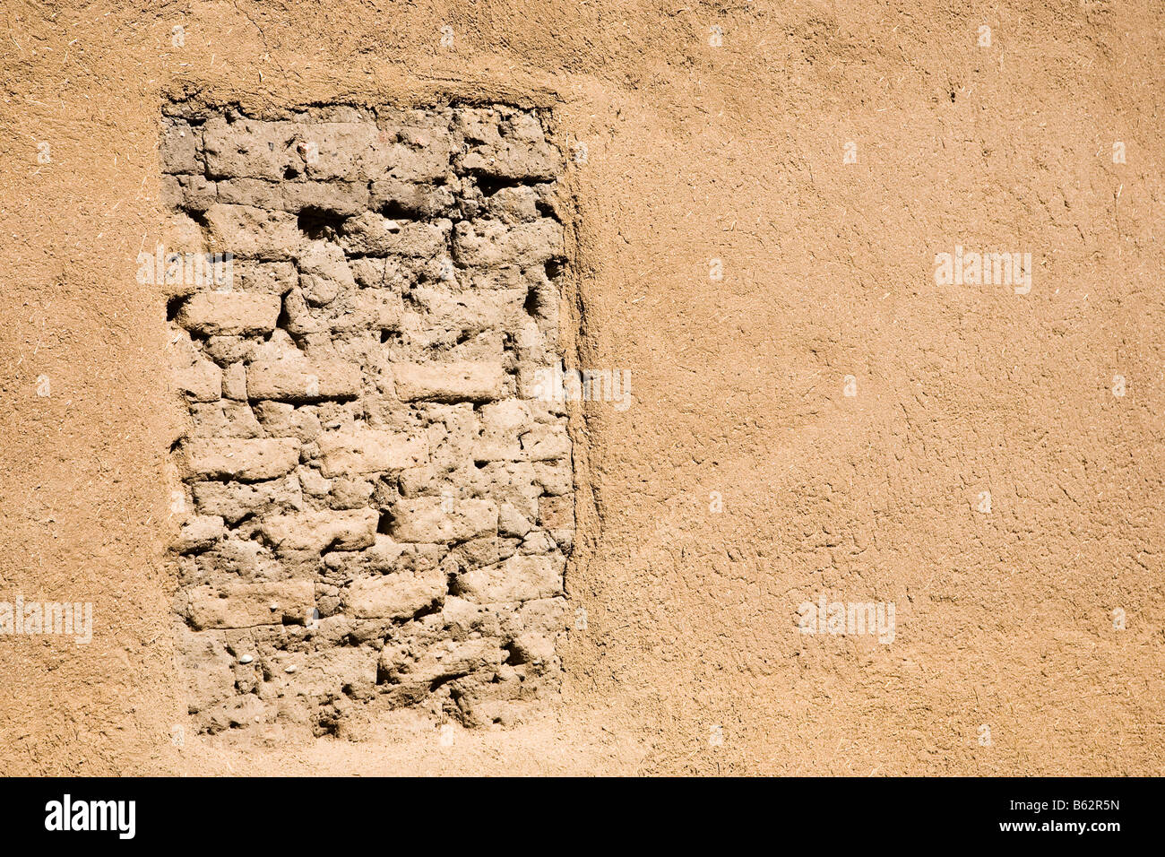 Clay-colored wall with mudbrick in a window frame Stock Photo - Alamy