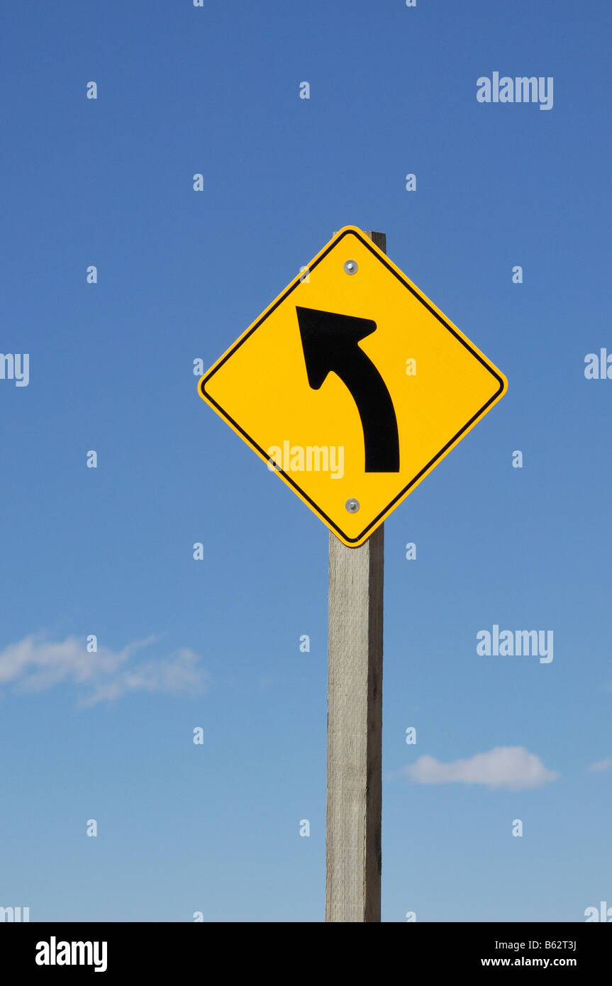 Upcoming turn yellow road sign set against a blue sky Pigeon Lake ...