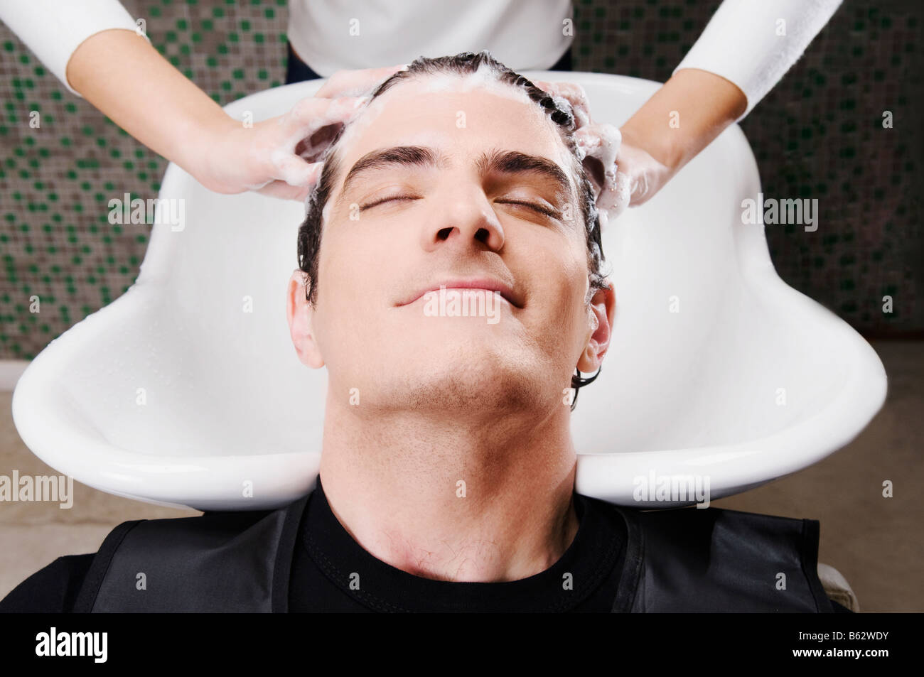 Mid adult man getting hair shampooed at salon Stock Photo - Alamy