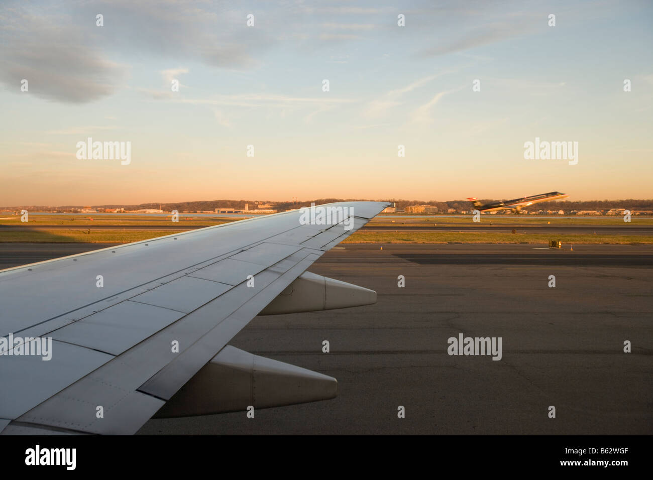 USA Washington DC Setting sun lights wing of passenger jet approaching ...