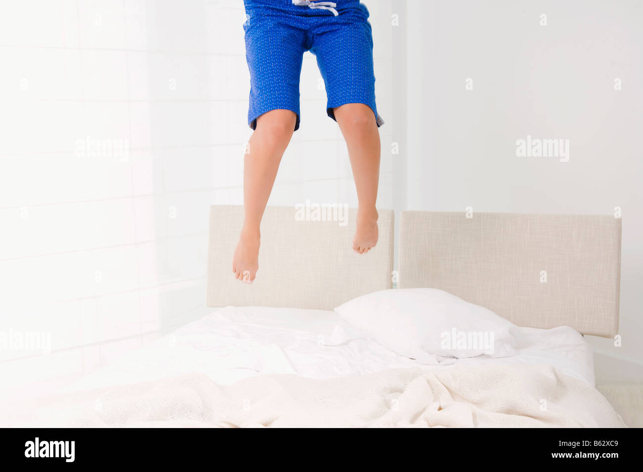 Low section view of a person jumping on the bed Stock Photo - Alamy