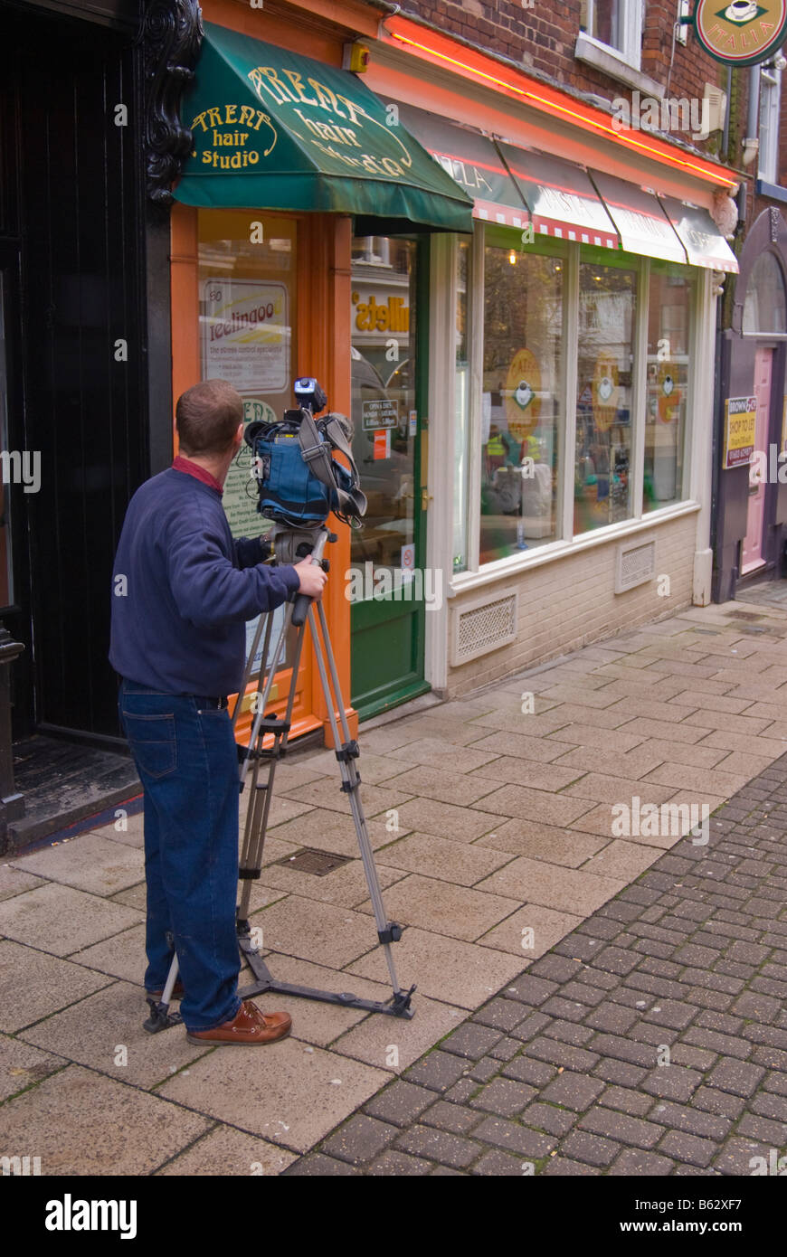 Professional Cameraman with tv camera on tripod waiting for someone to ...