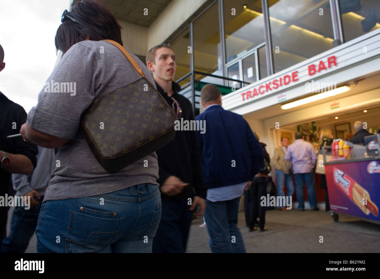A woman with a designer bag outside a bar Stock Photo - Alamy