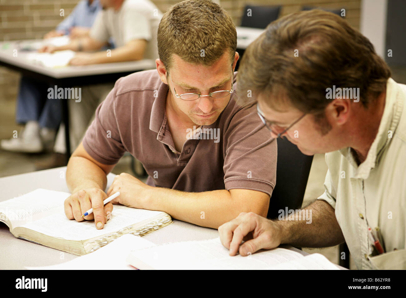 Two adult education students studying together in class Stock Photo - Alamy