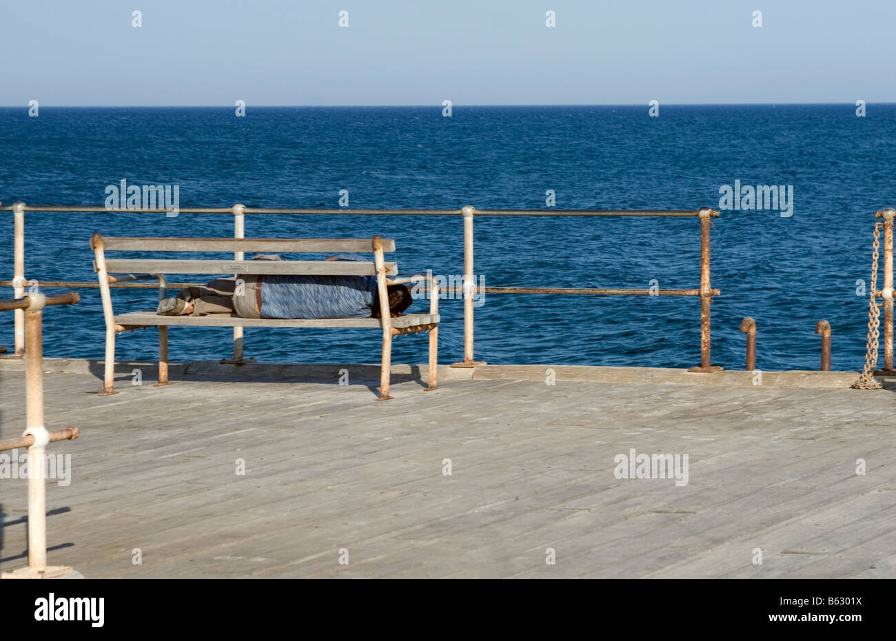 Homeless man on beach bench hi-res stock photography and images - Alamy
