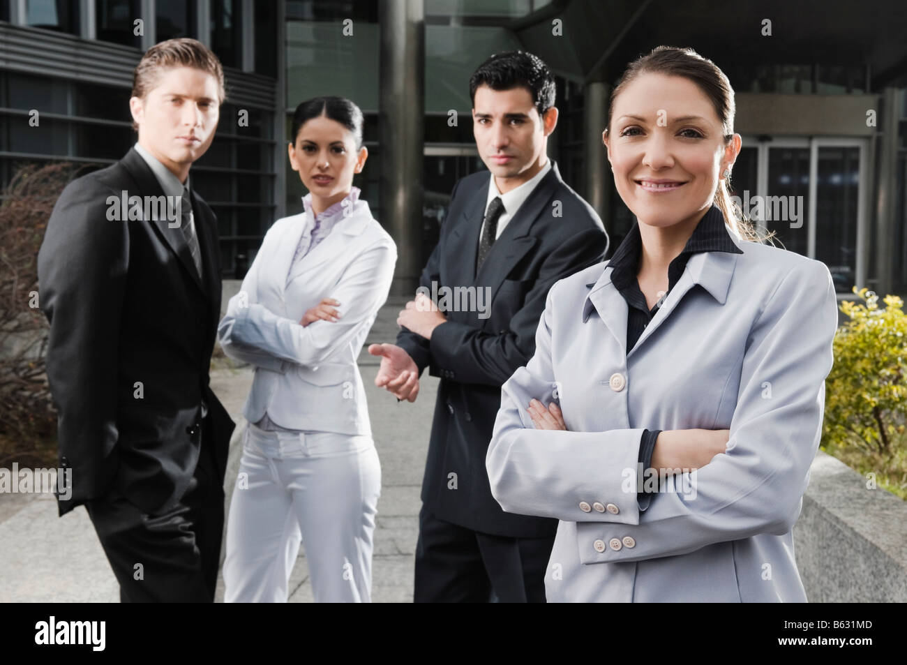 Four business executives standing together Stock Photo - Alamy