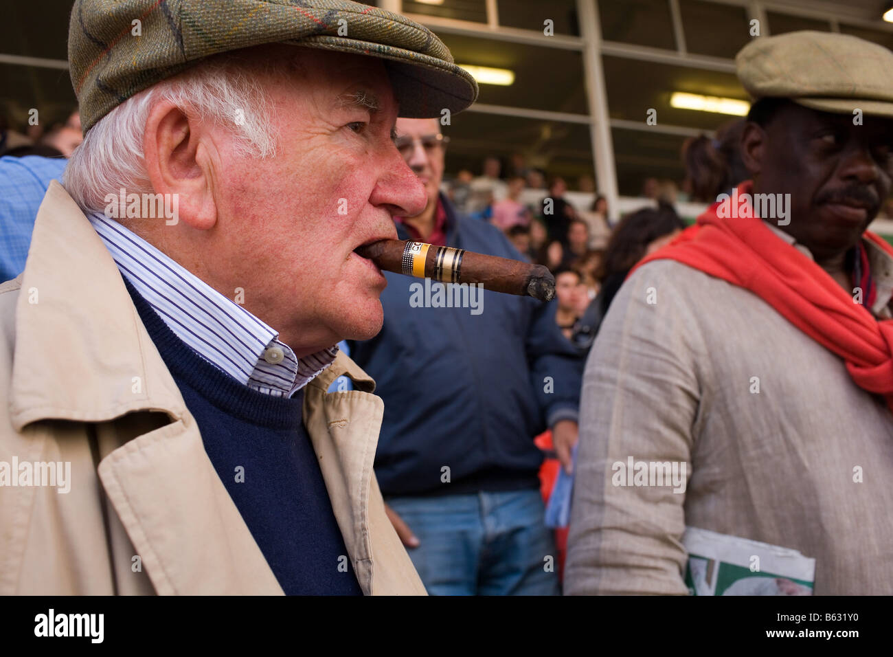 An old man in a cap smoking a cigar Stock Photo - Alamy