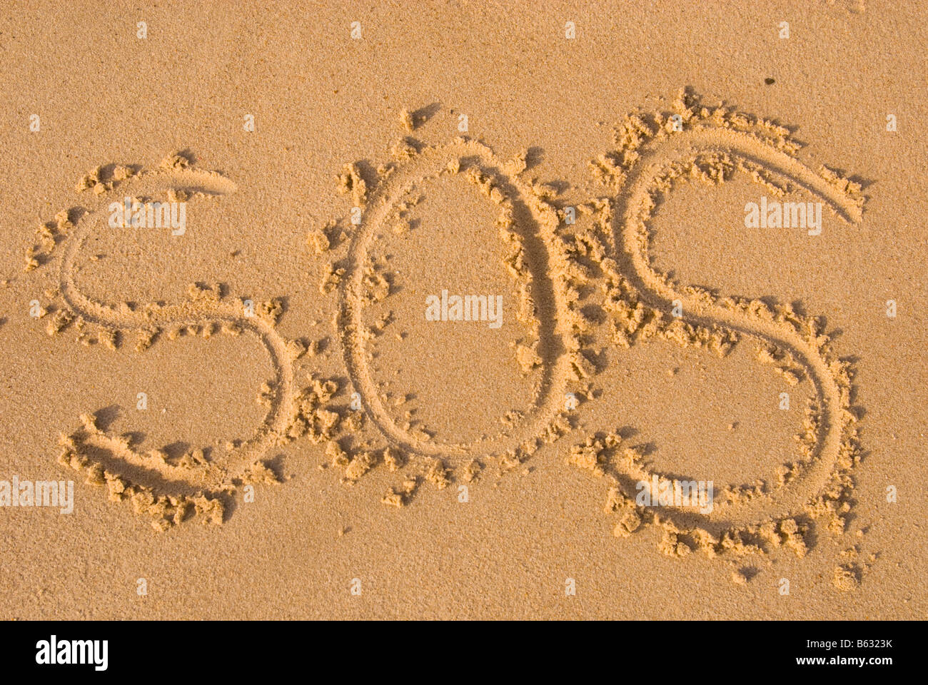 Sos written in sand on beach Stock Photo - Alamy