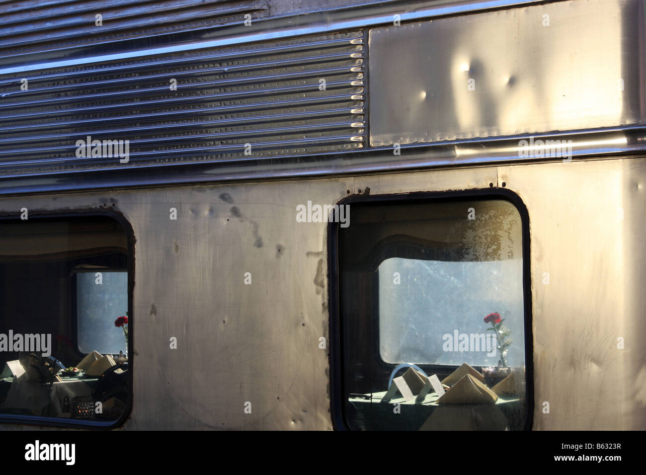 The set dinner tables with napkins and a flower on the dinner train car ...