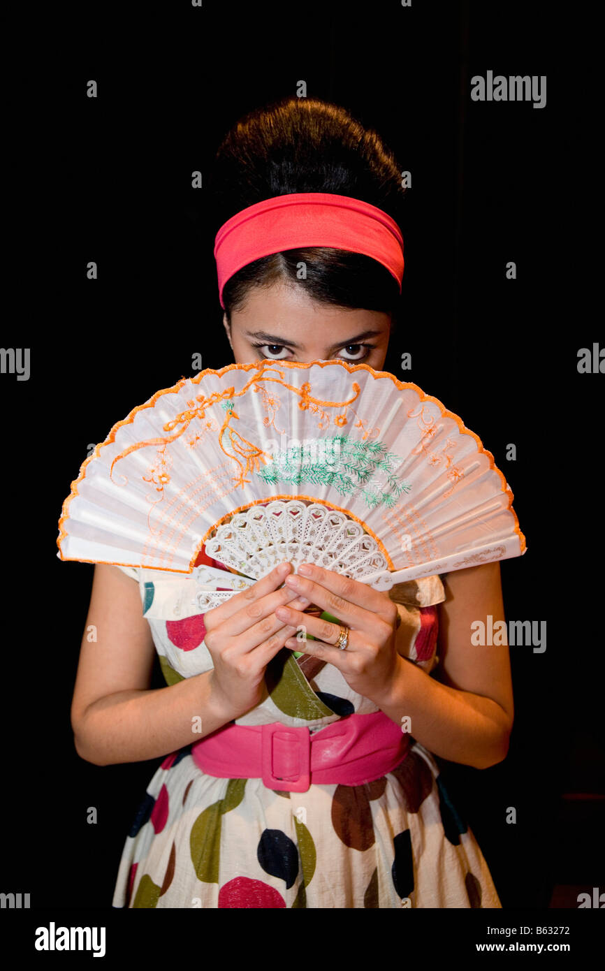 Portrait of a young woman holding a folding fan Stock Photo - Alamy