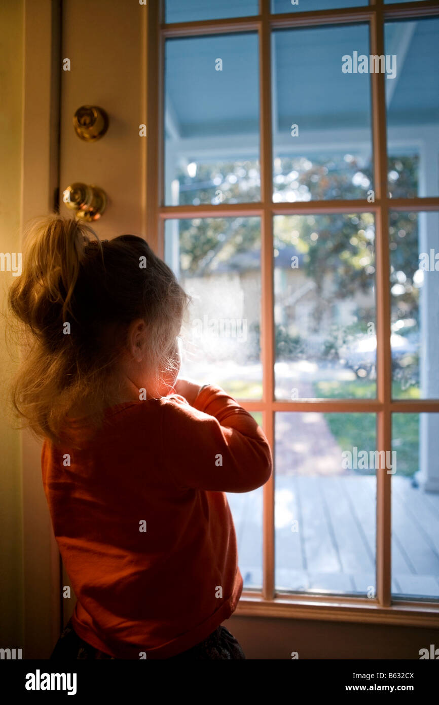 Rear view of a girl looking through a door Stock Photo - Alamy