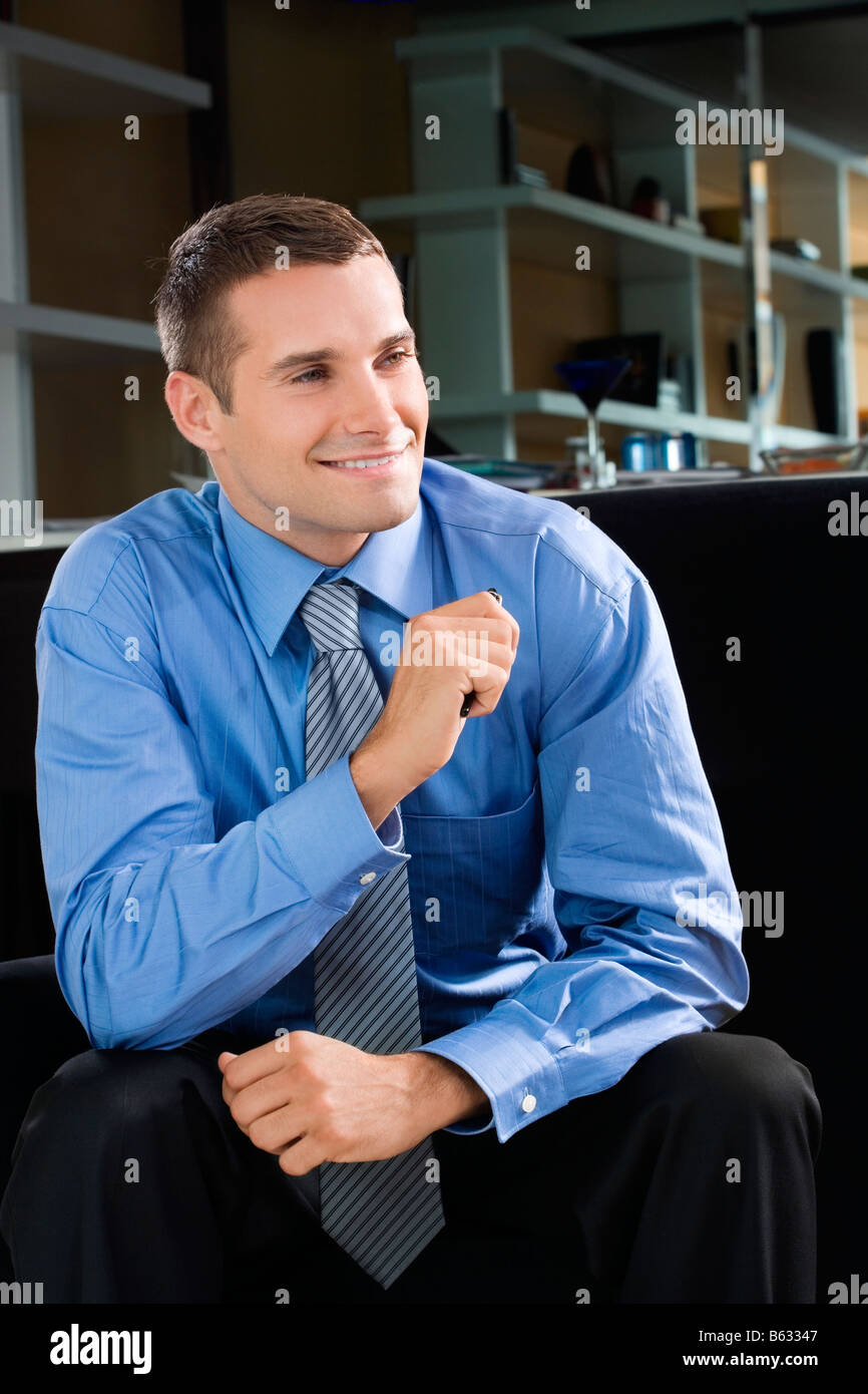 Young man sitting and smiling Stock Photo - Alamy