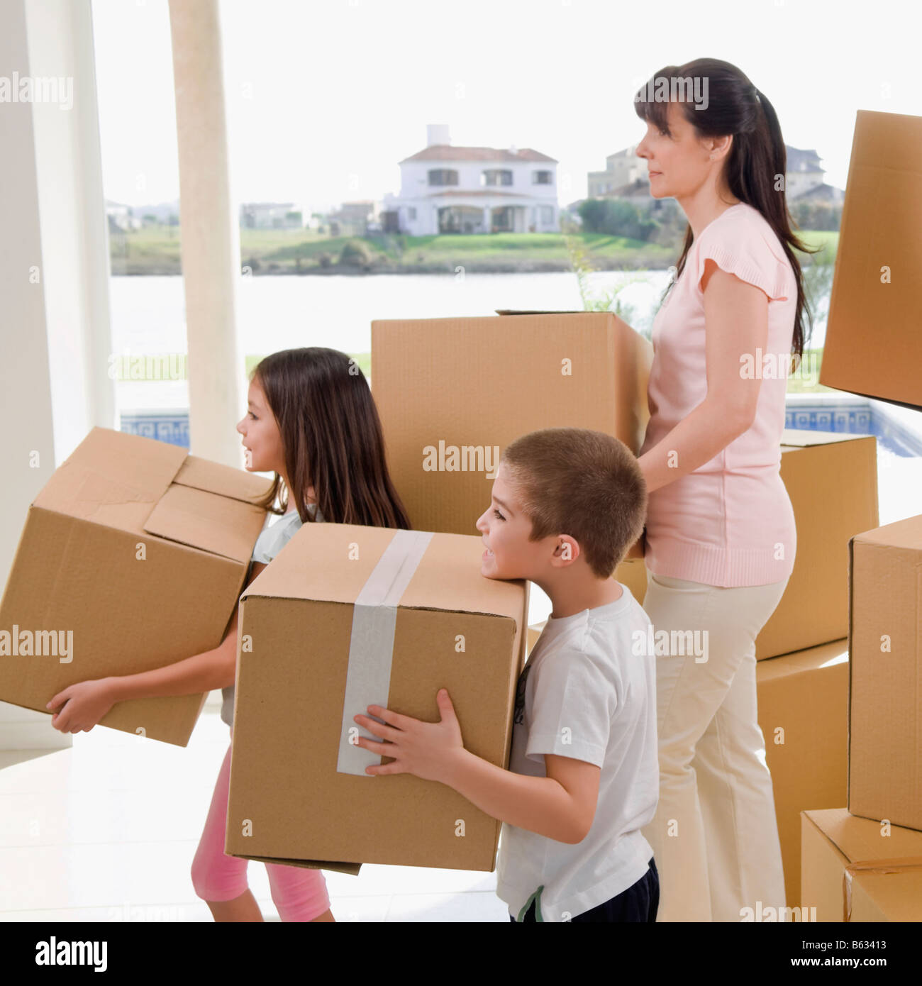 Side profile of a family carrying cardboard boxes Stock Photo - Alamy