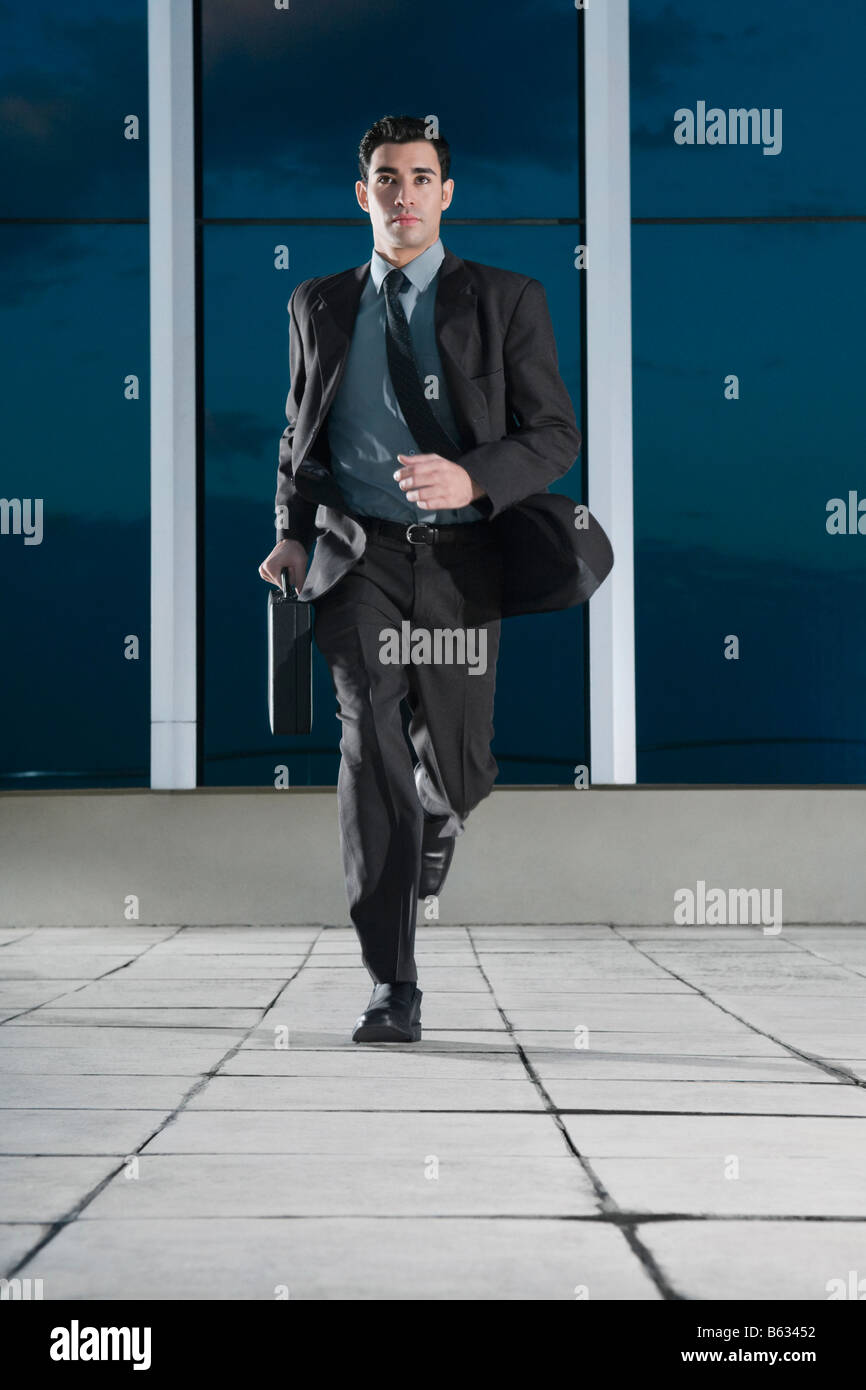 Businessman running in the corridor of an office Stock Photo - Alamy