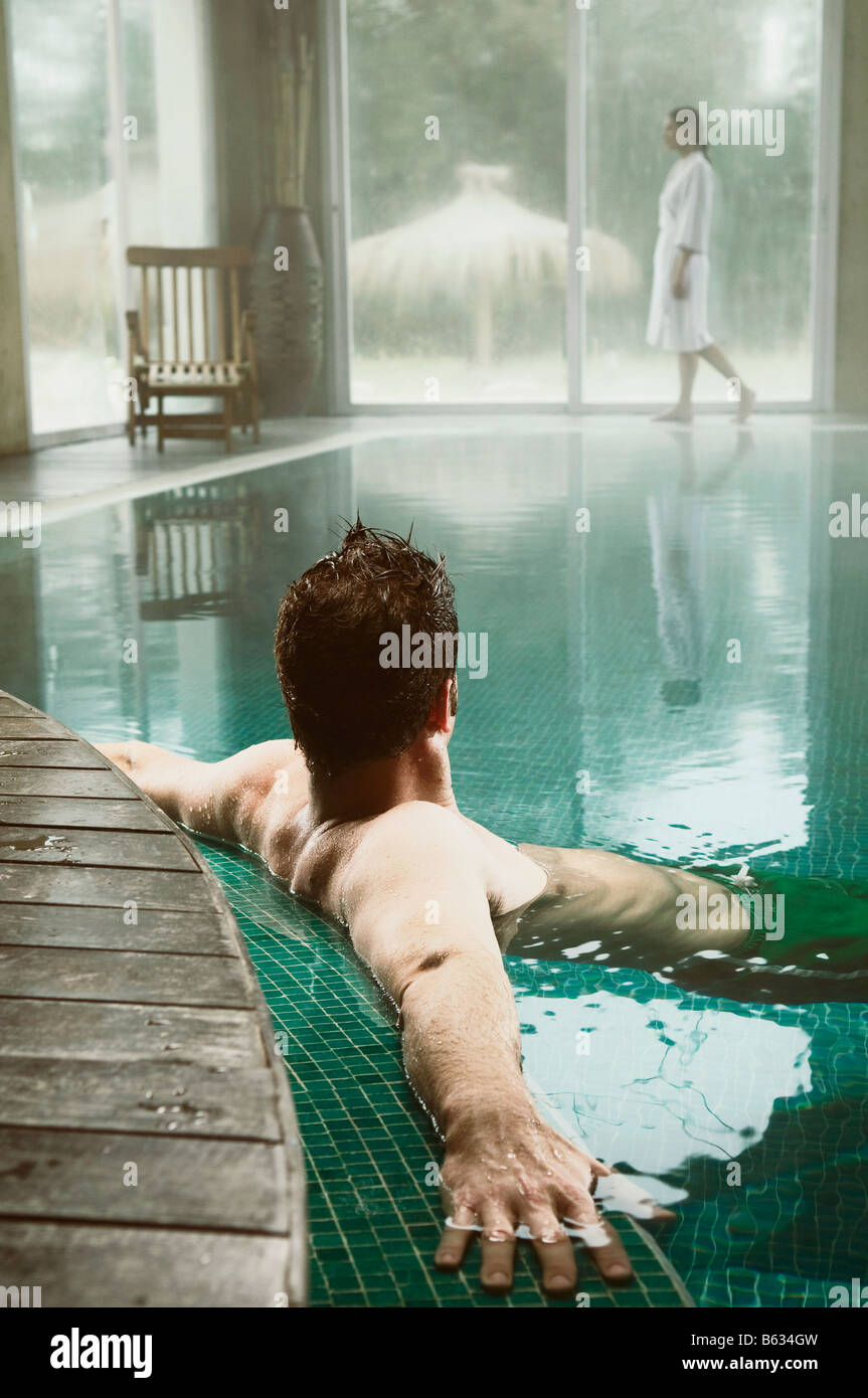 Mid adult man leaning at the poolside Stock Photo - Alamy