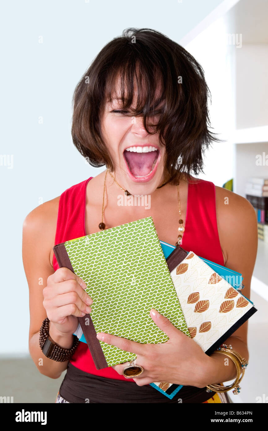Young woman holding books and shouting Stock Photo - Alamy