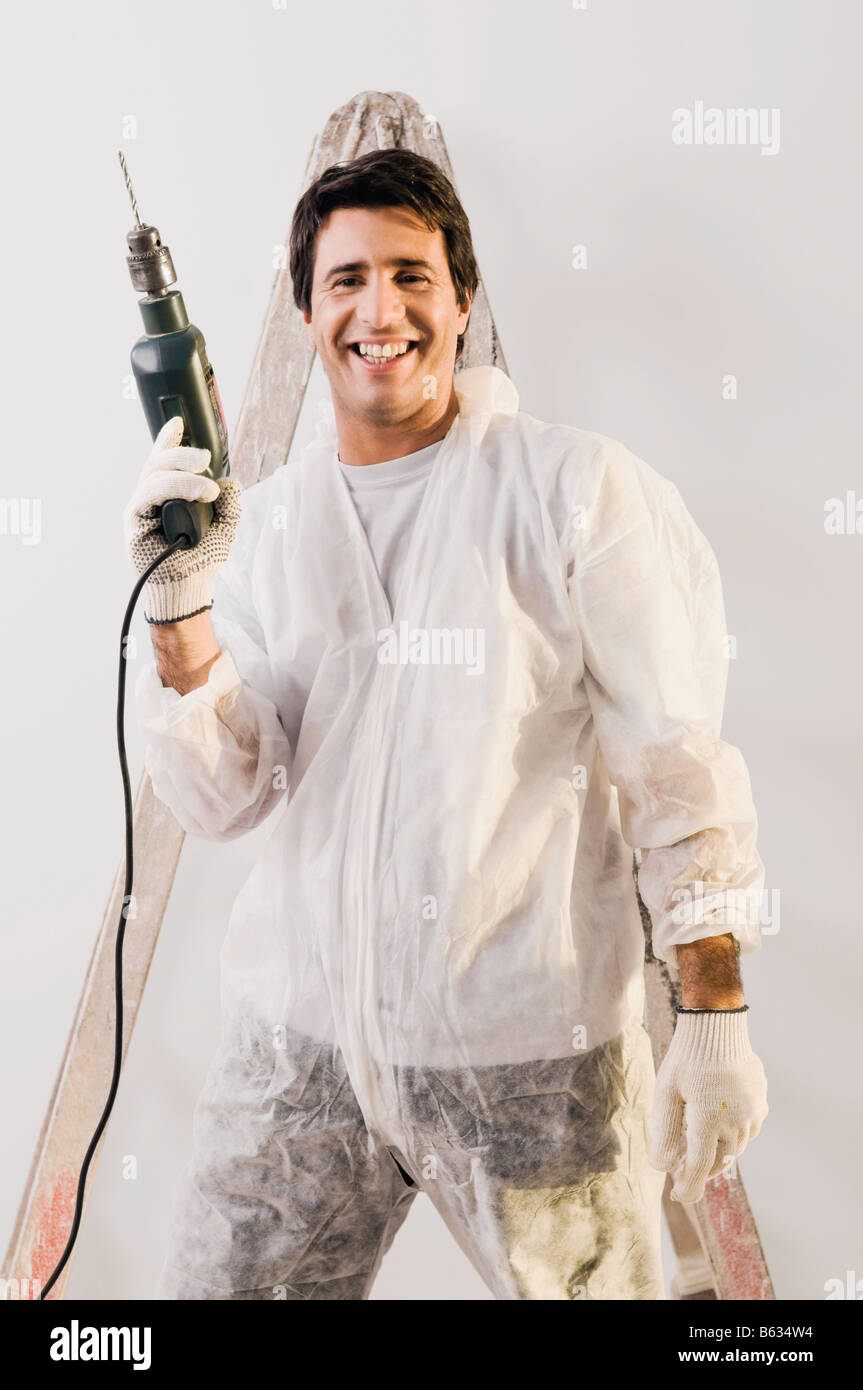 Portrait of a mid adult man holding drill machine and smiling Stock ...