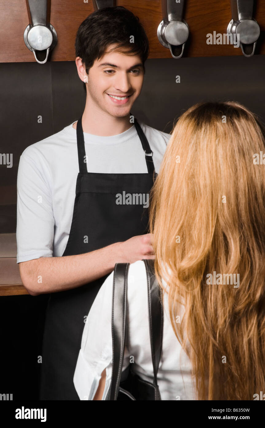 Coffee shop owner talking to a customer and smiling Stock Photo - Alamy