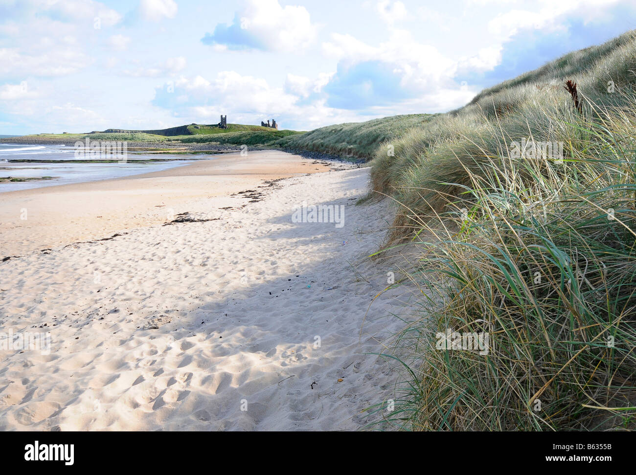 View of Dunstanburgh castle overlooking a sandy Embleton beach in ...