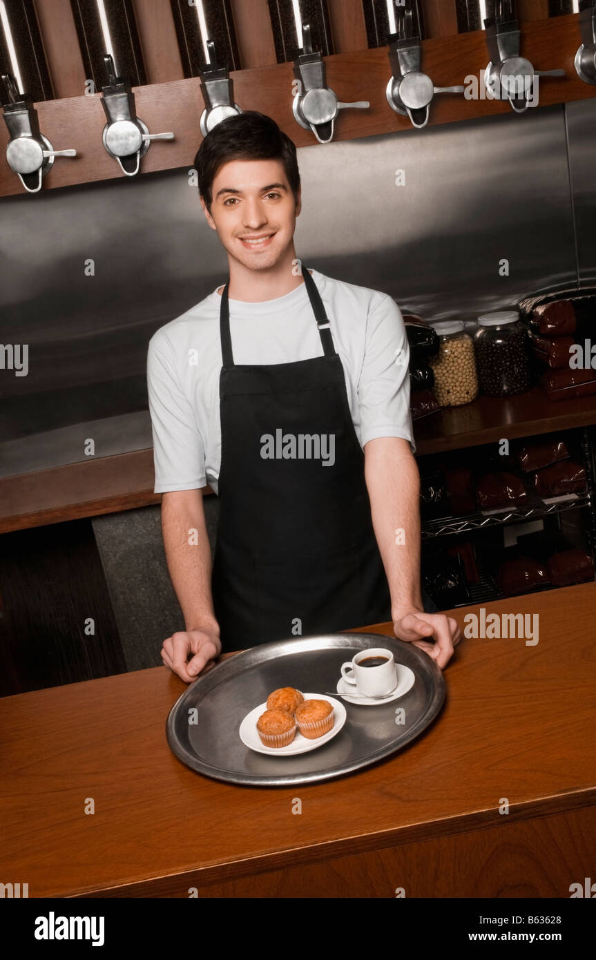 Cafe owner standing at a cafe counter and smiling Stock Photo - Alamy