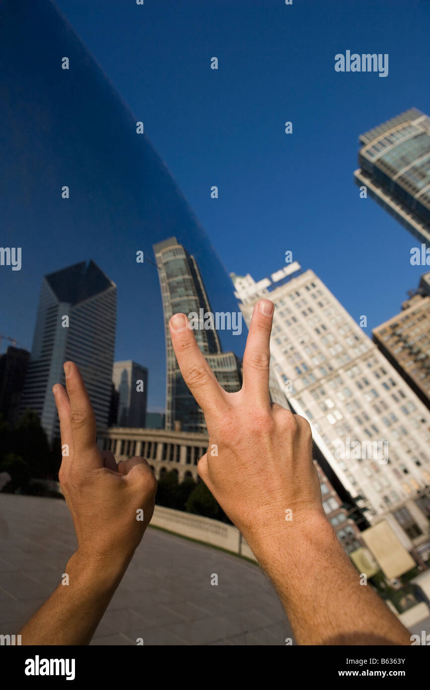 Person showing a peace sign in front of a sculpture, Cloud Gate ...