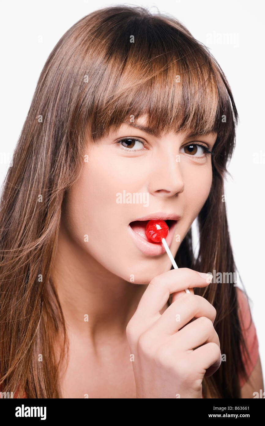 Close-up of a young woman eating a lollipop Stock Photo - Alamy