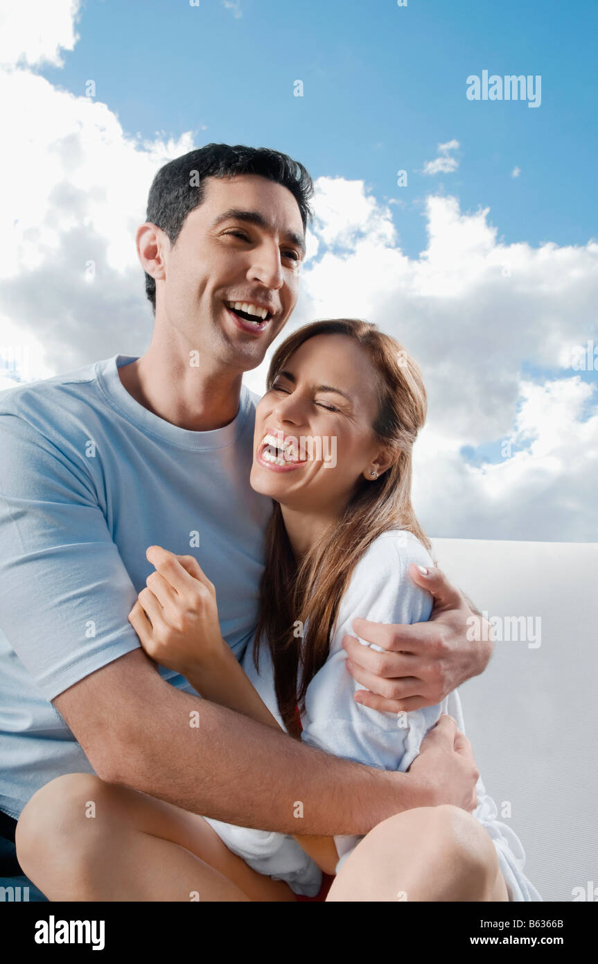 Mid adult man embracing a mid adult woman and smiling Stock Photo - Alamy