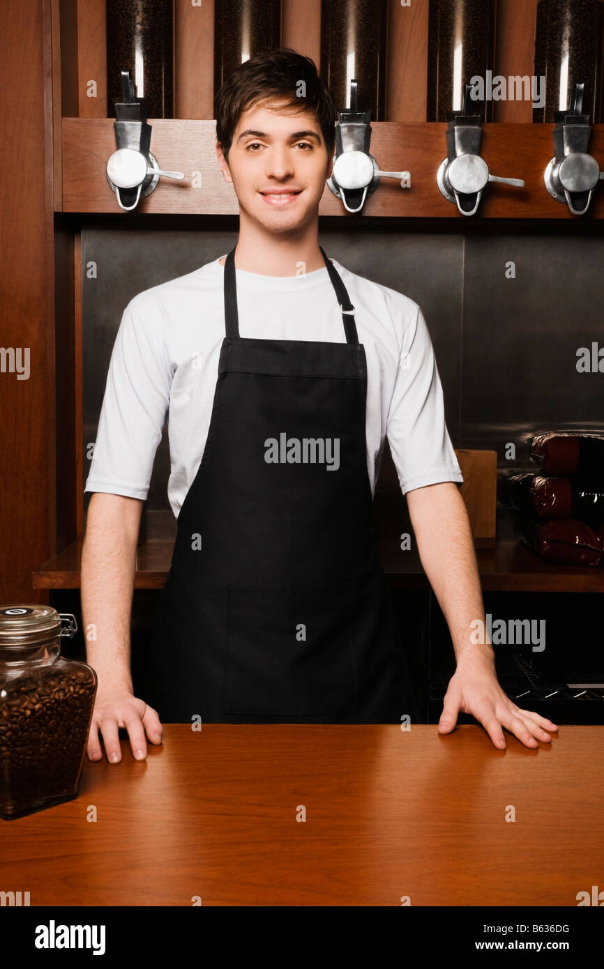 Owner standing at a cafe counter and smiling Stock Photo - Alamy