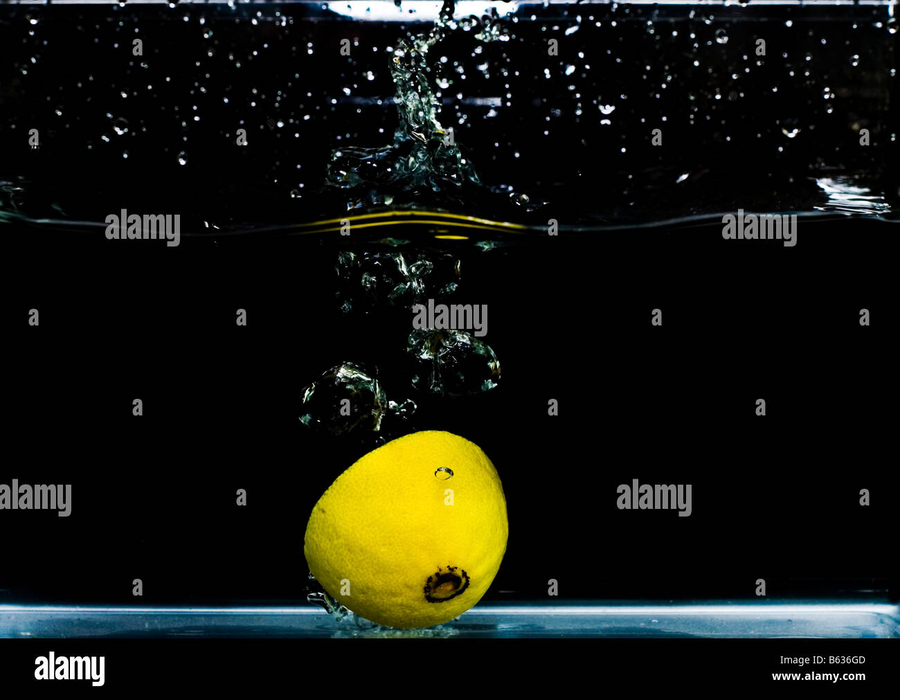 Lemon dropped into water Stock Photo - Alamy