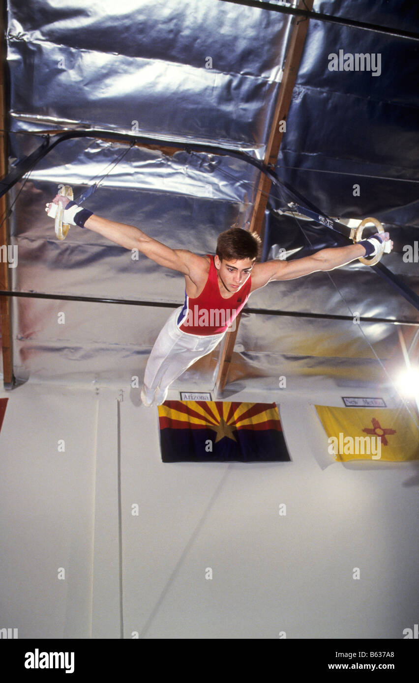 Teen boy performs gymnastics on rings Stock Photo - Alamy