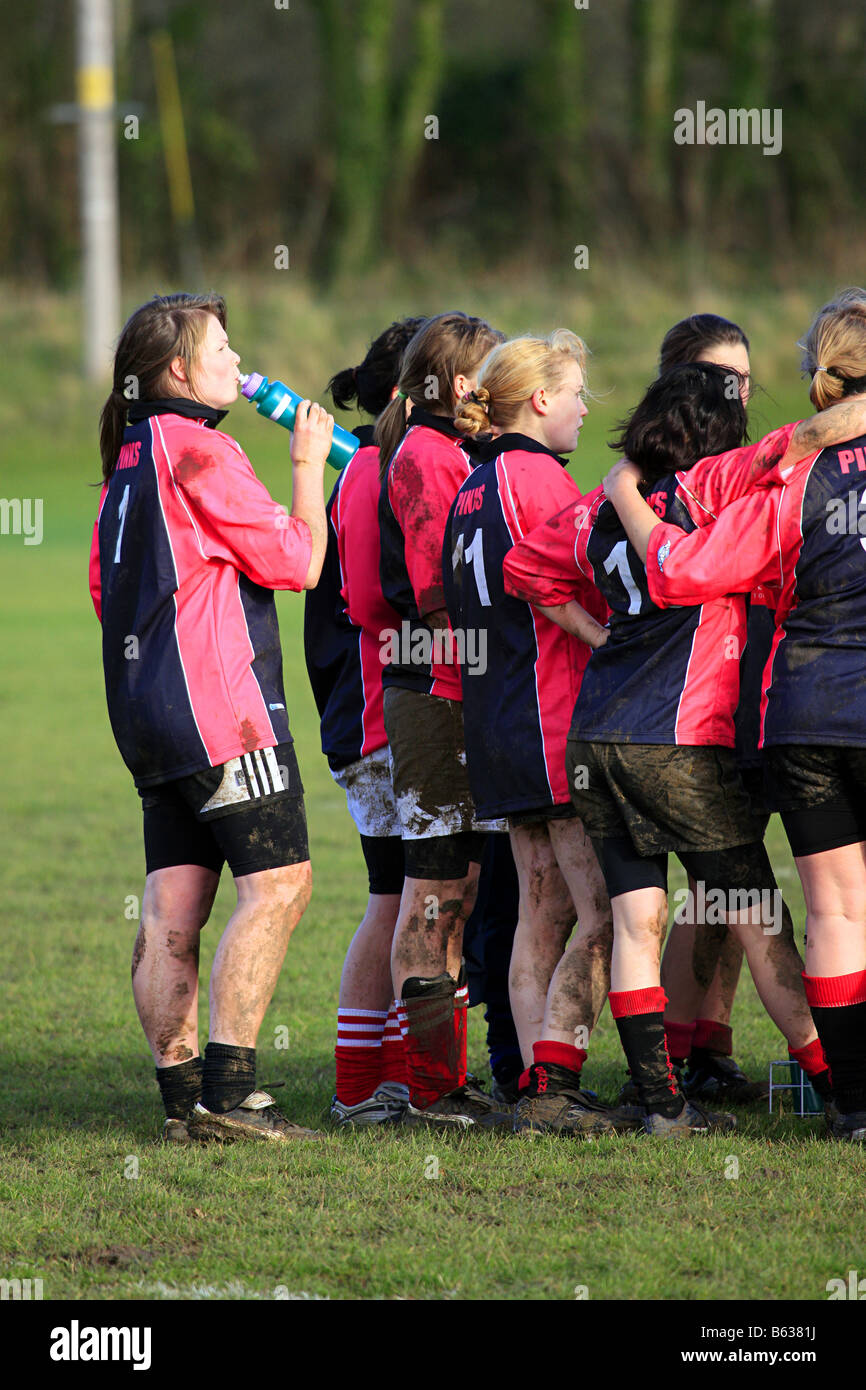 Teenage girsl Rugby players standing on a cold wet pitch on an autumn ...