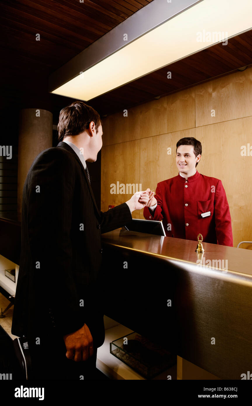 Waiter giving cardkey to a businessman Stock Photo - Alamy