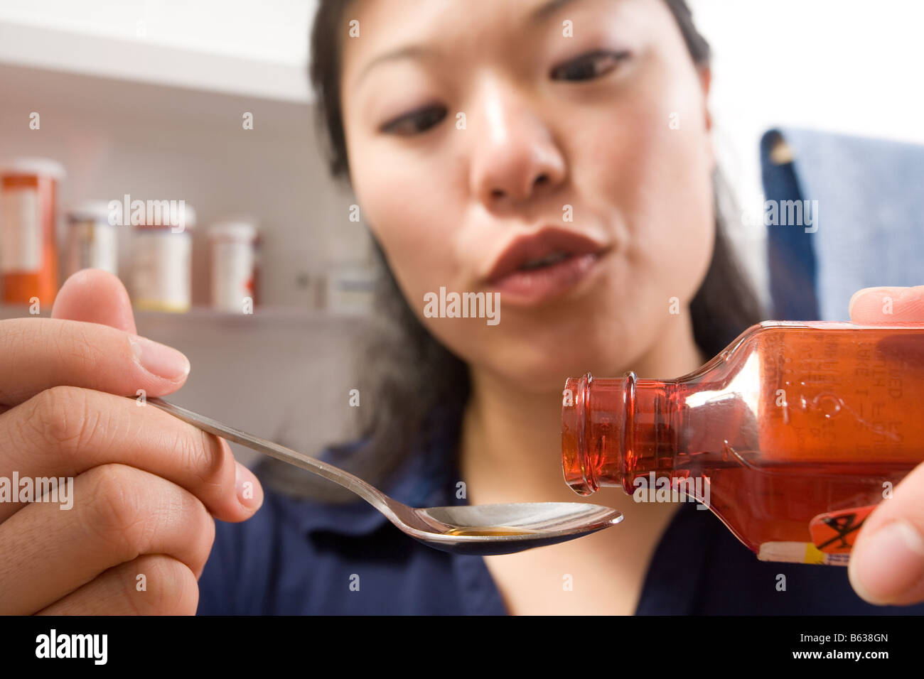 Asian woman measures liquid medicine Stock Photo - Alamy
