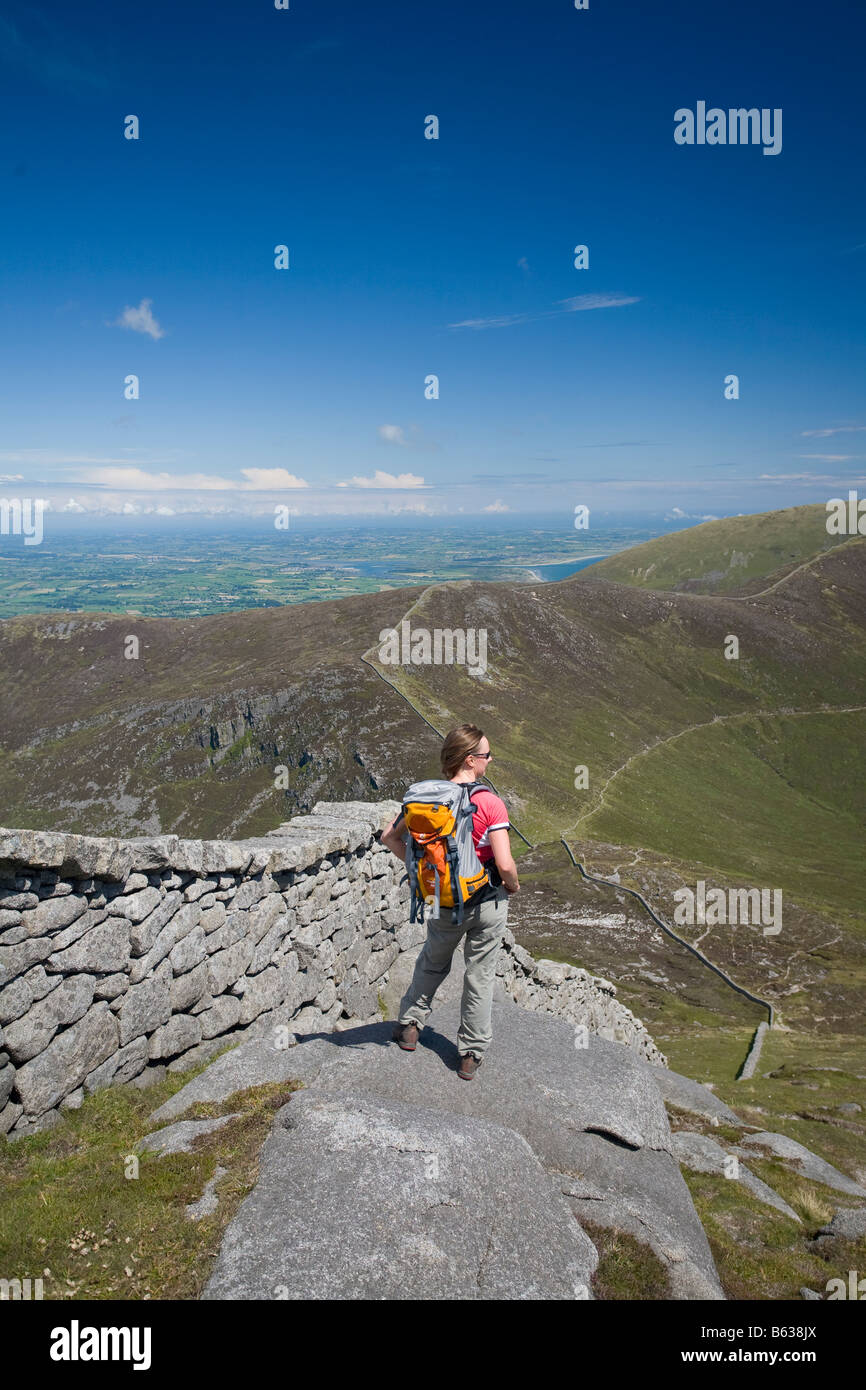 Walker beside the Mourne Wall on the slopes of Slieve Bearnagh, Mourne ...