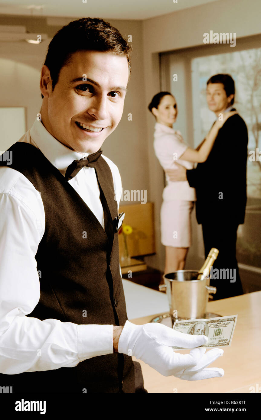Portrait of a waiter holding US paper currency Stock Photo - Alamy