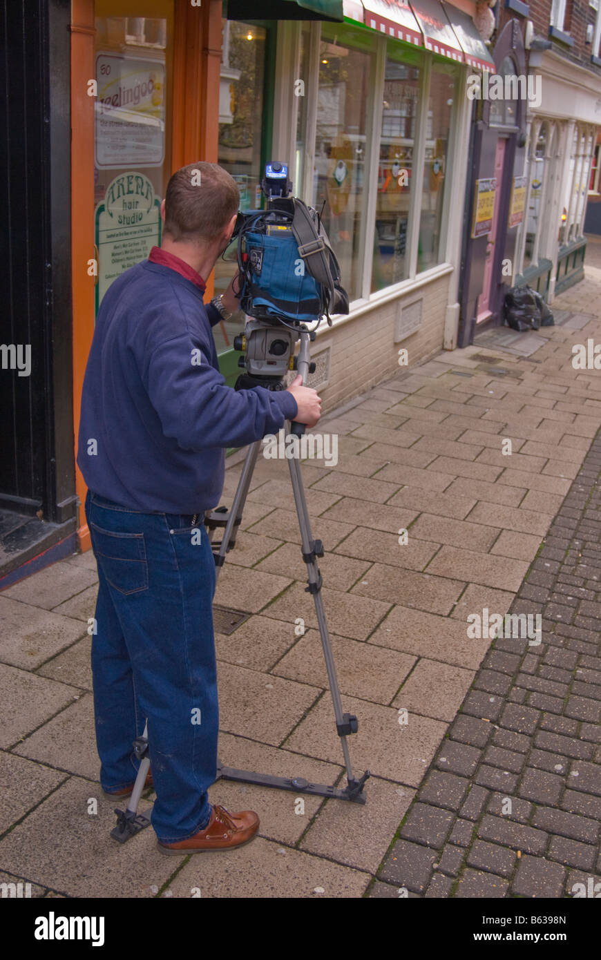Professional Cameraman with tv camera on tripod waiting for someone to ...
