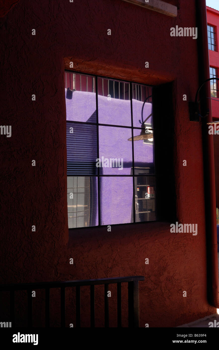 Reflection of door, window, and purple wall into window on red wall ...