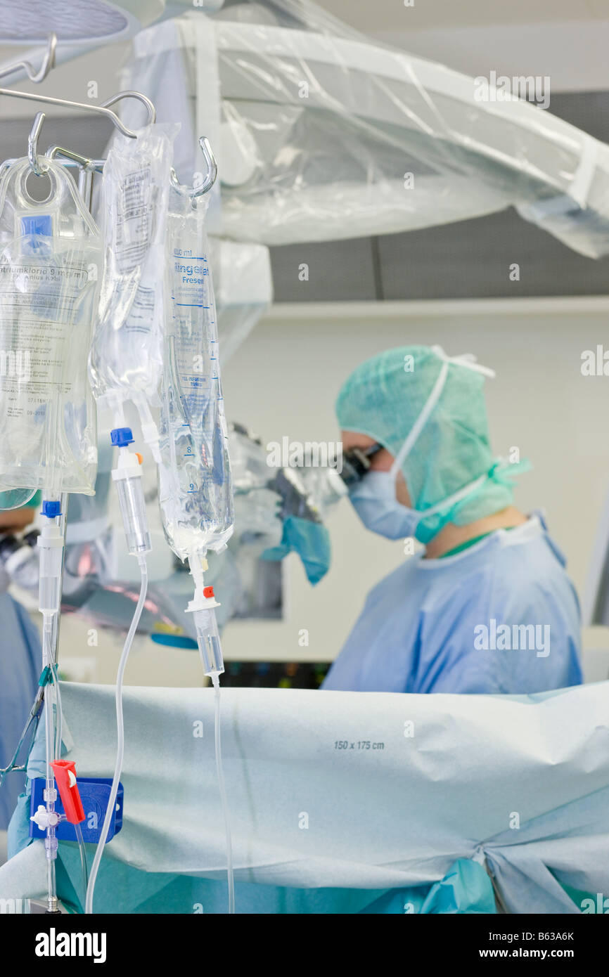 Neurosurgeon using microscope during surgical procedure to remove a ...