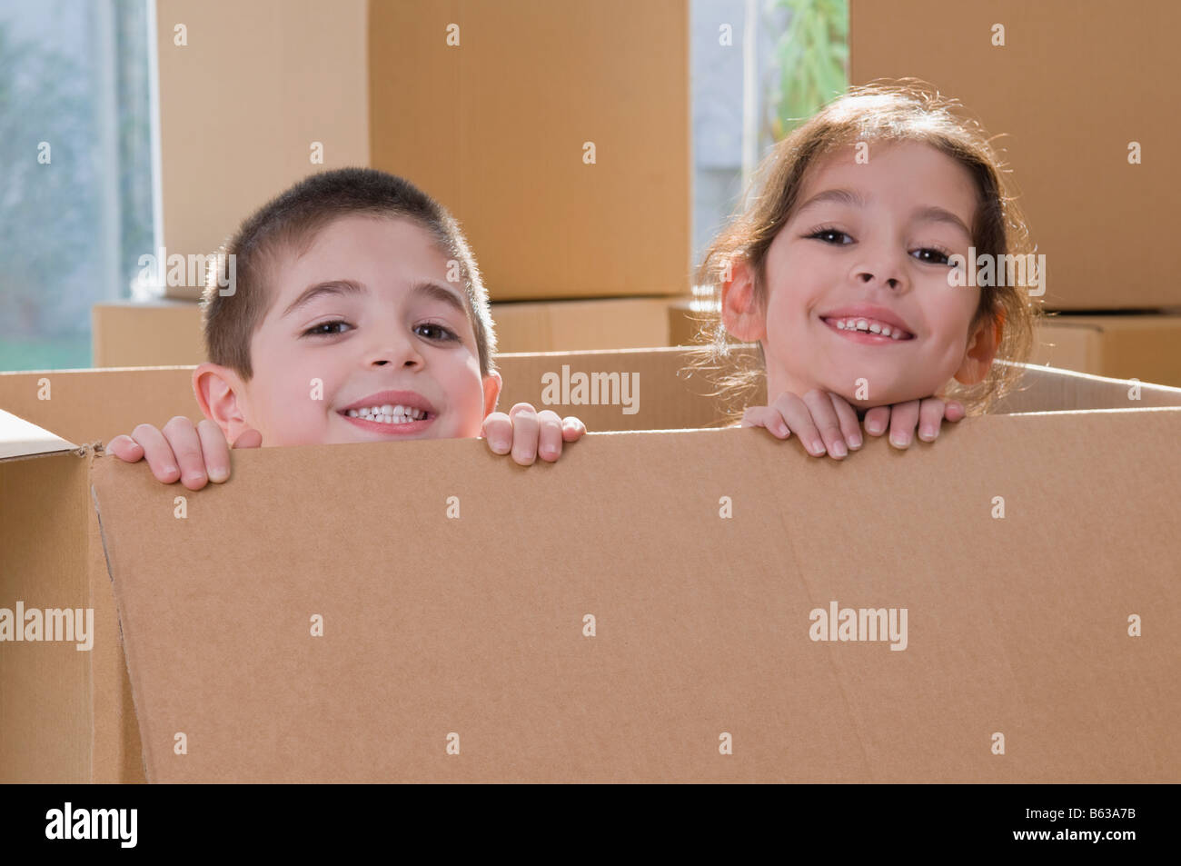 Portrait of two children smiling in a cardboard box Stock Photo - Alamy