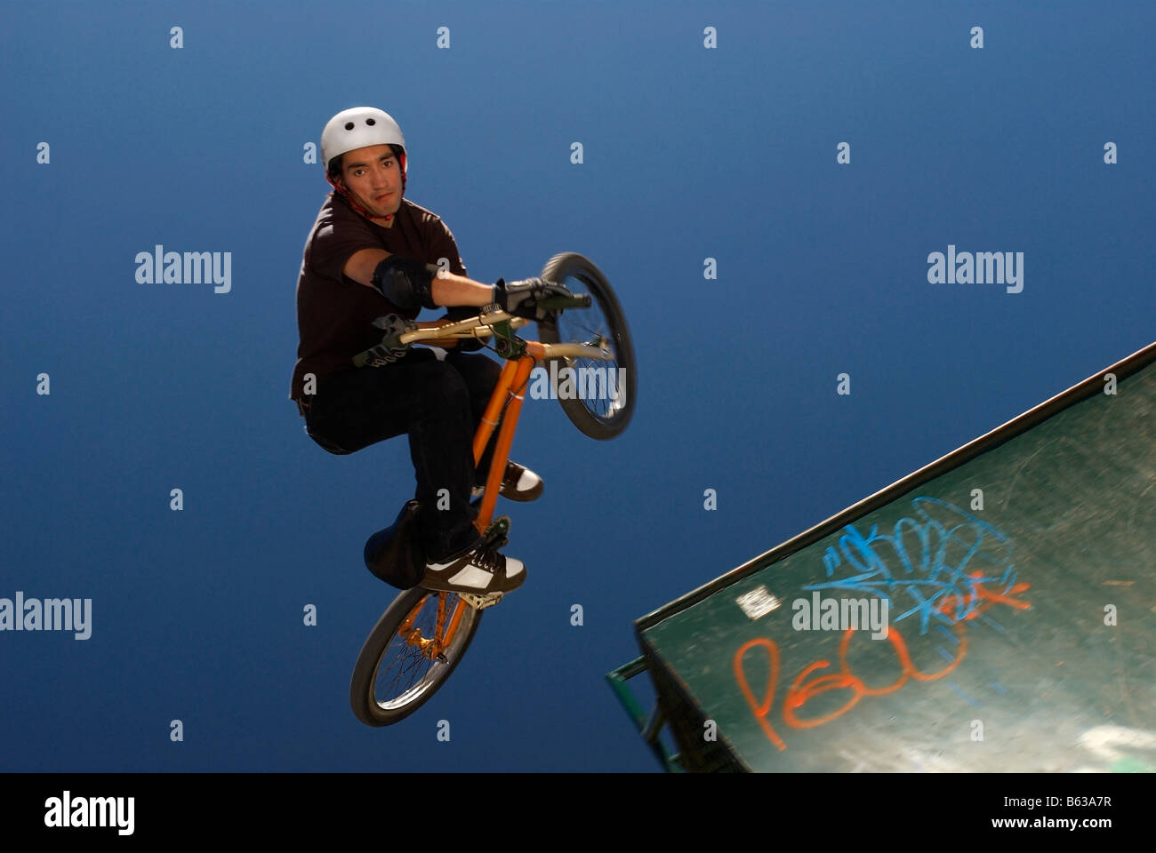 Portrait of a BMX cyclist performing in mid-air Stock Photo - Alamy