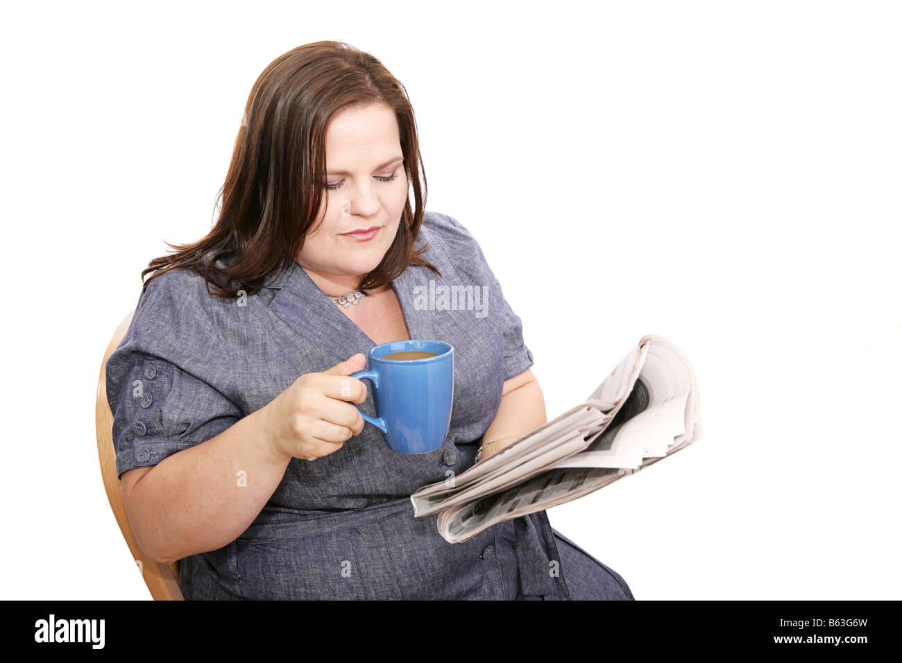 Beautiful plus sized woman reading the newspaper and drinking coffee ...