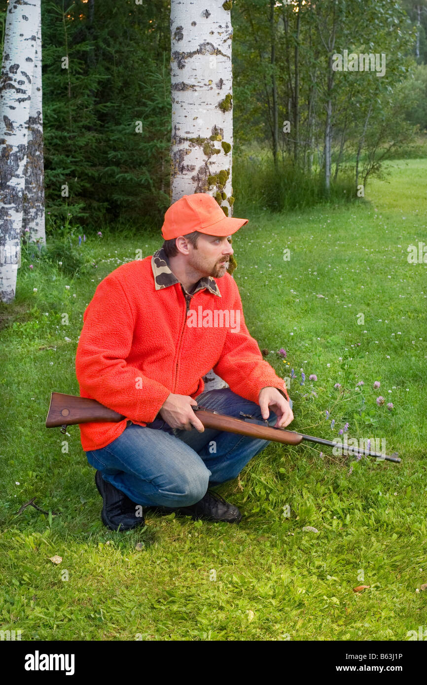male hunter is crouching and waiting for his prey Stock Photo - Alamy