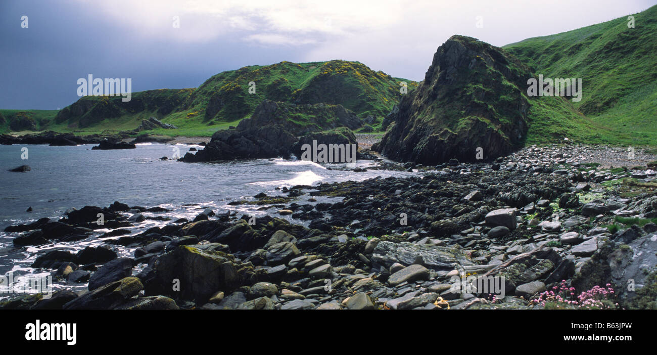 Coast path rugged coastline of the Moray Firth at low tide with rocky ...
