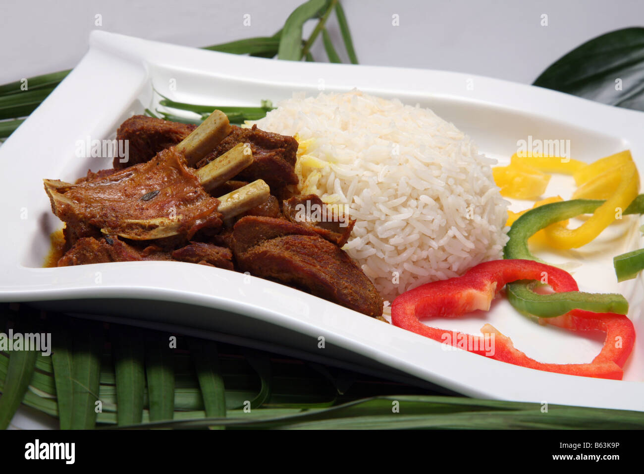 Caribbean meal containing lamb chops with rice Stock Photo - Alamy
