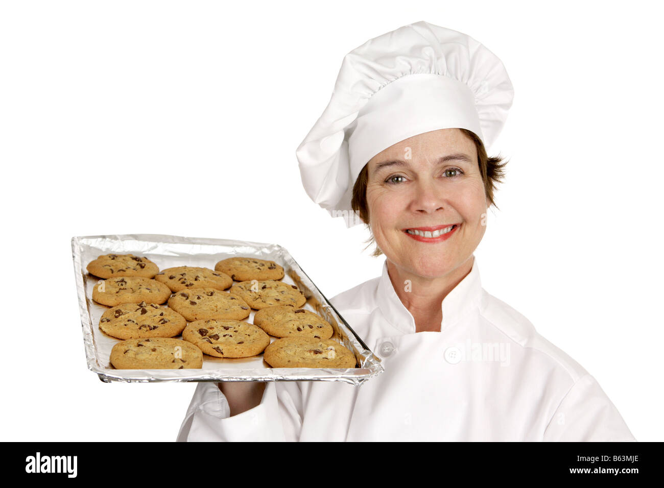 Pretty chef holding up a freshly baked batch of toll house cookies ...