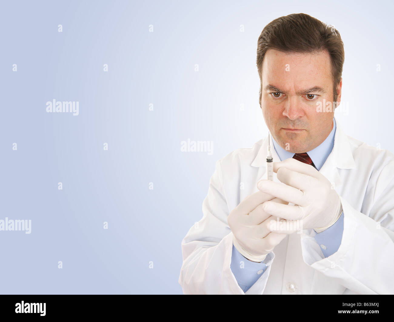 Doctor preparing a syringe to give a shot Blue background with room for ...