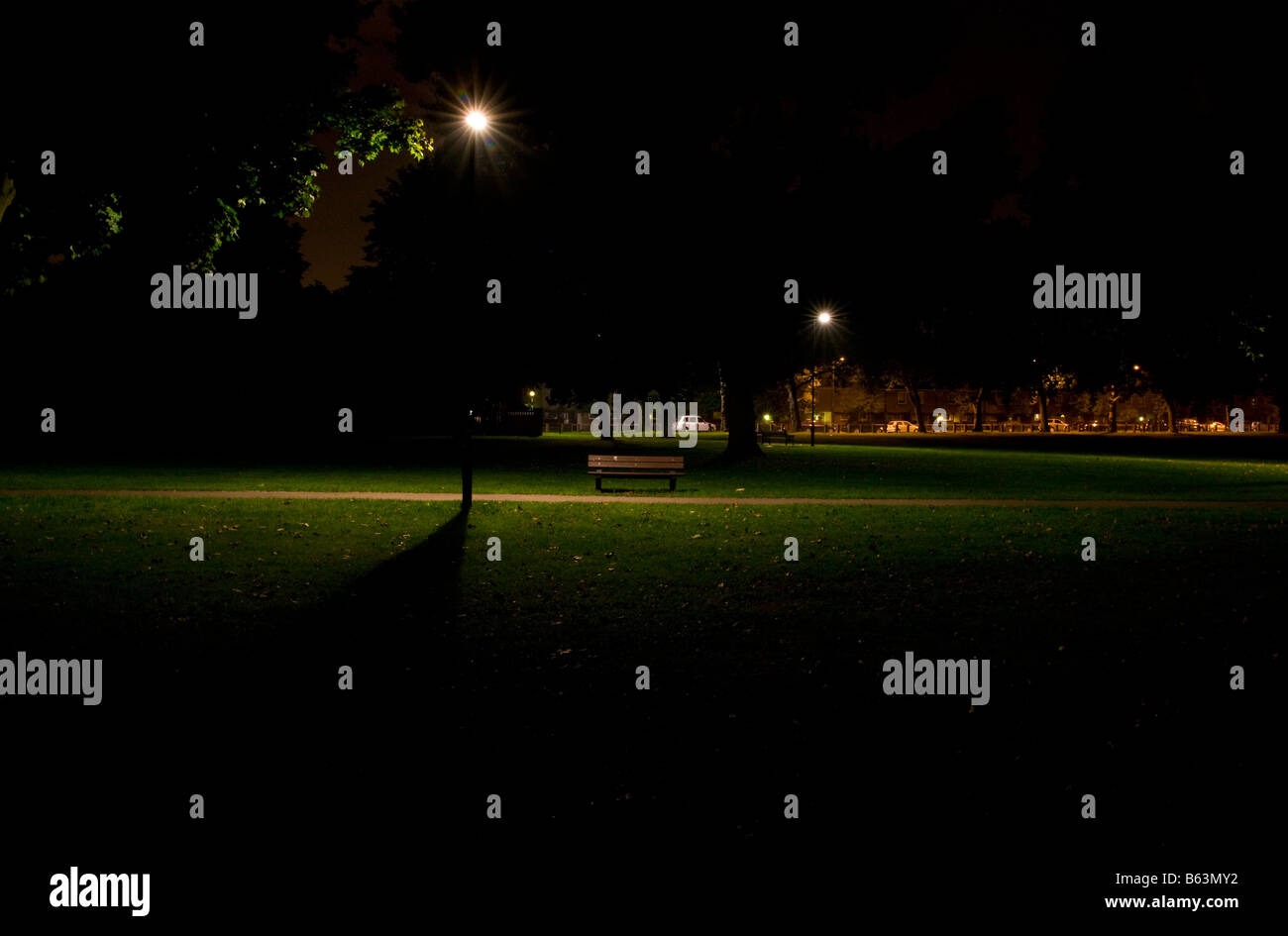 a streetlight shines shallowly on a park bench Stock Photo - Alamy