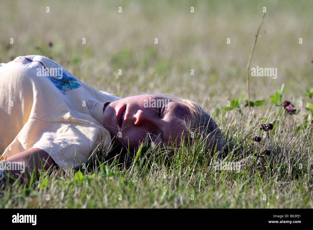 A teenage girl is injured and laying on her back in a field Stock Photo ...