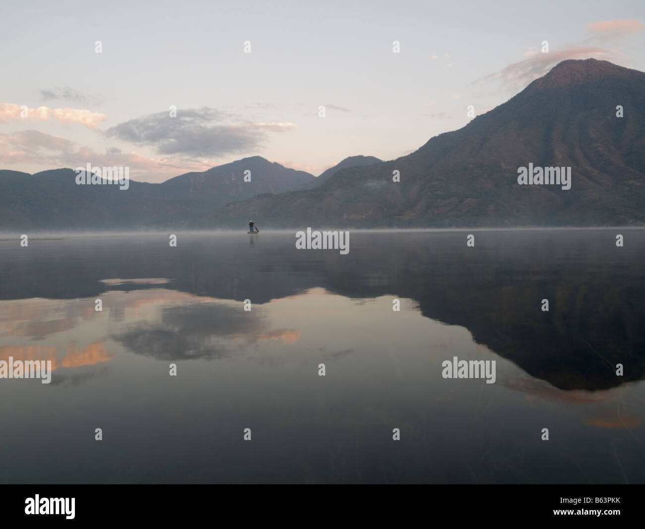 A fishermen and reflection on the surface of lake Stock Photo - Alamy