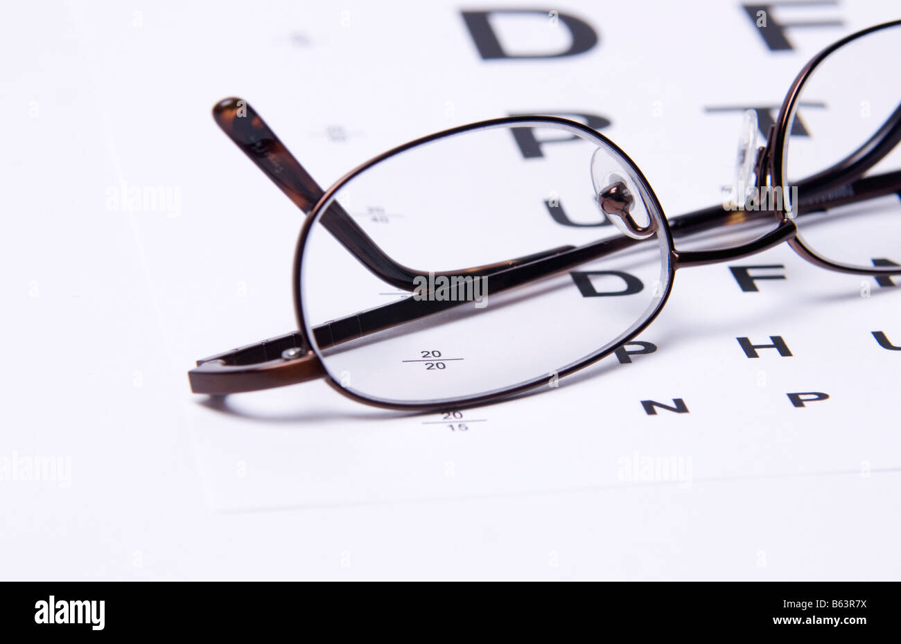 Reading glasses on a vision chart, with focus on the 20/20 line Stock ...